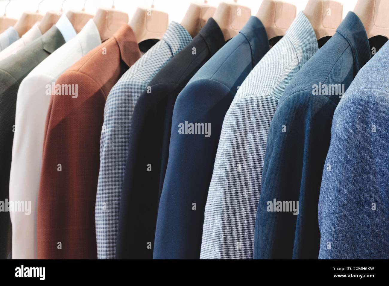A row of blue and white jackets hang on a rack. The jackets are all ...