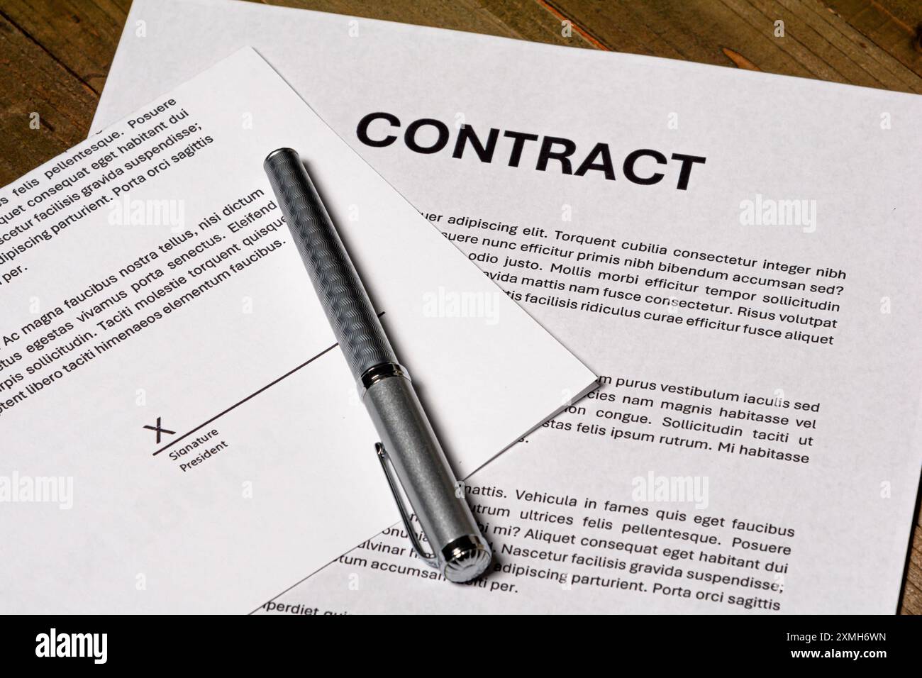 Paper contract form with a signature about to be signed on a signature ...