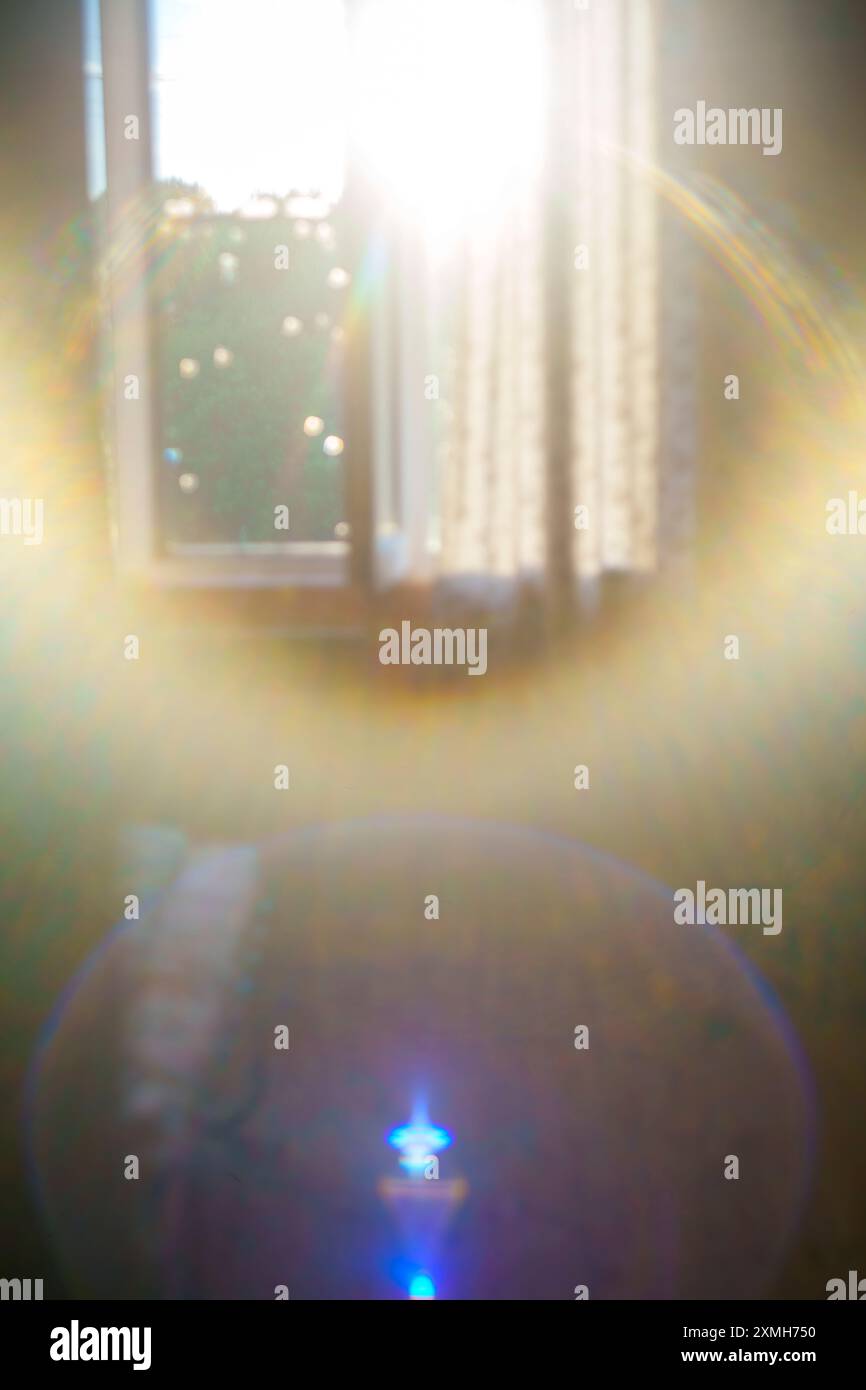 Sunlight shines through a window, creating a soft lens flare effect ...