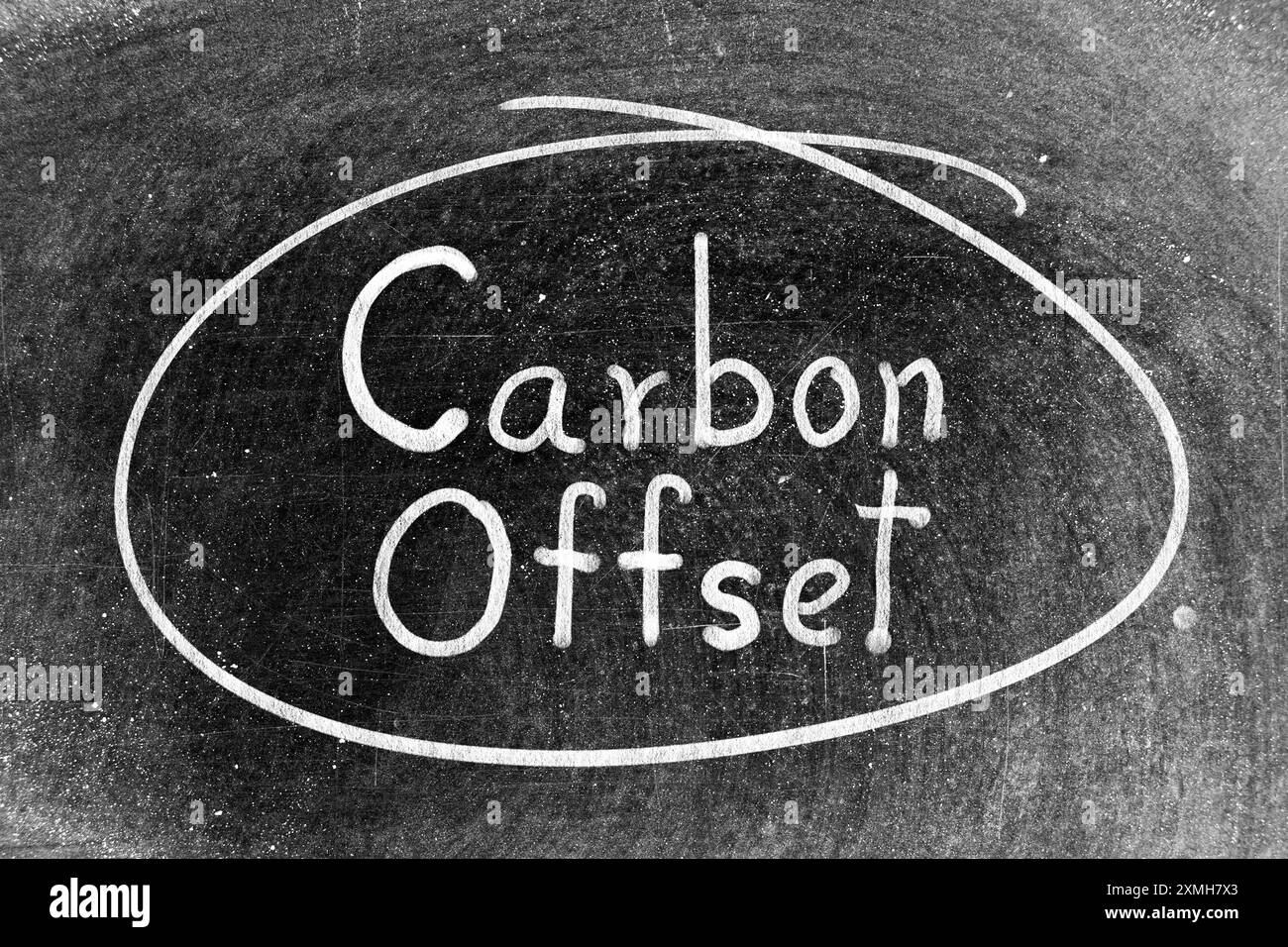 White chalk hand writing in word carbon offset and circle shape on ...