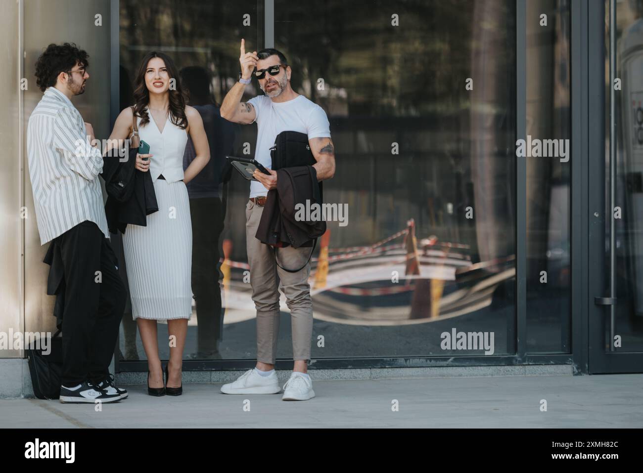 Young professionals waiting outside a modern office building Stock ...