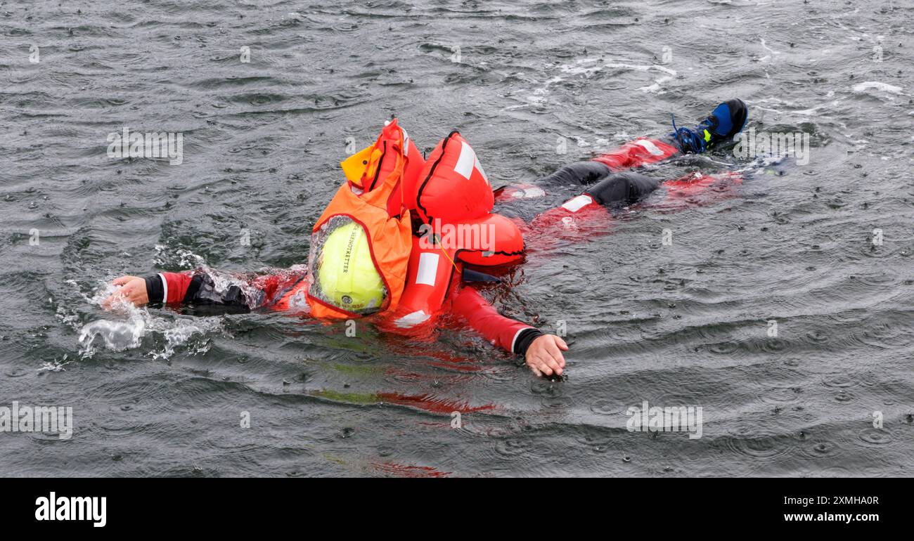 28 July 2024, Schleswig-Holstein, Grömitz: A sea rescuer demonstrates ...