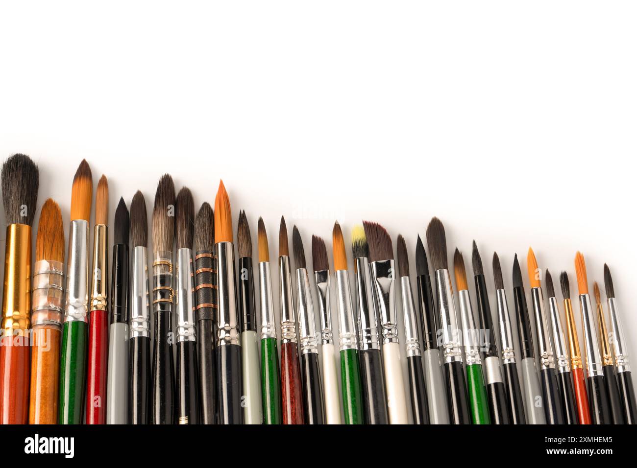 Mix of paint brushes in a row isolated on a white background. Top view ...