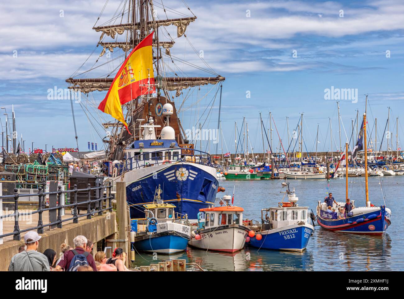 Three small fishing boats are moored together and a large trawler and a ...