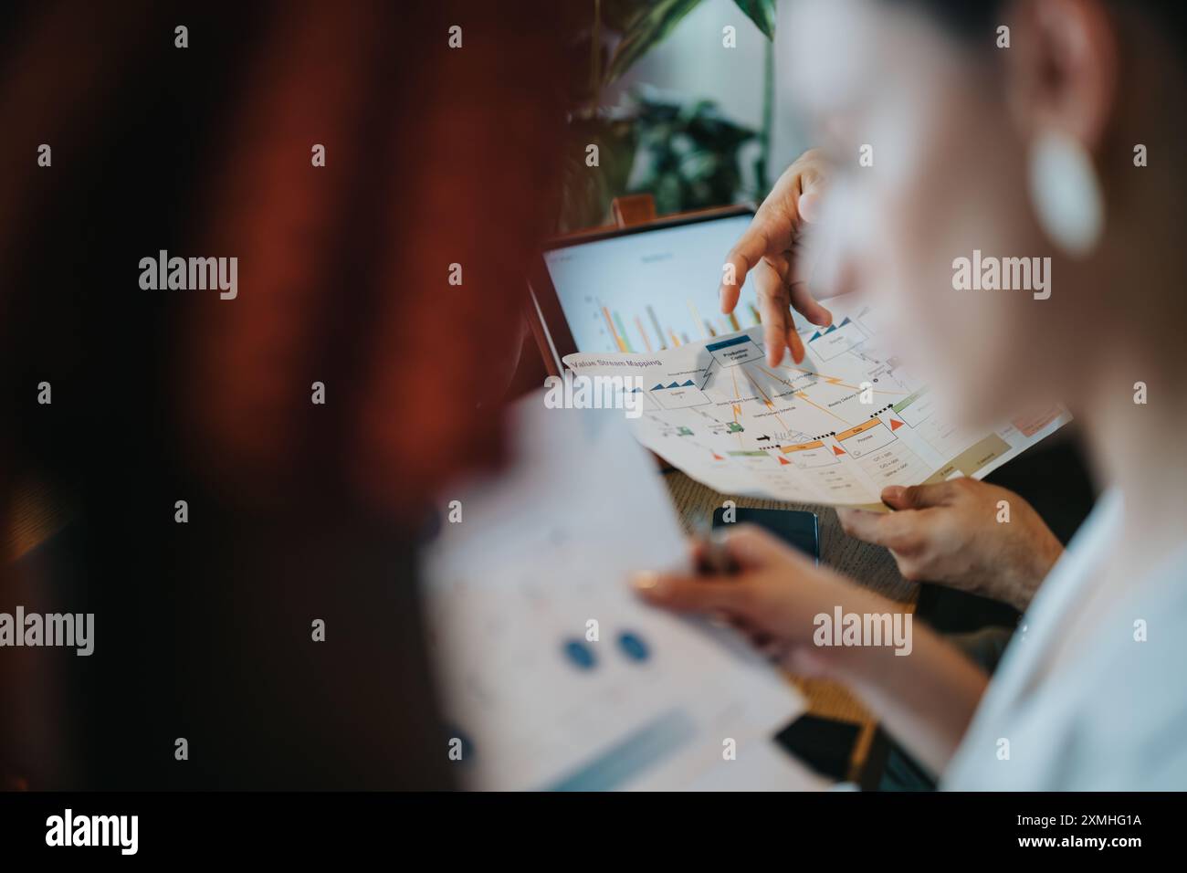 Businesspeople analyzing charts and graphs during a coffee bar meeting ...