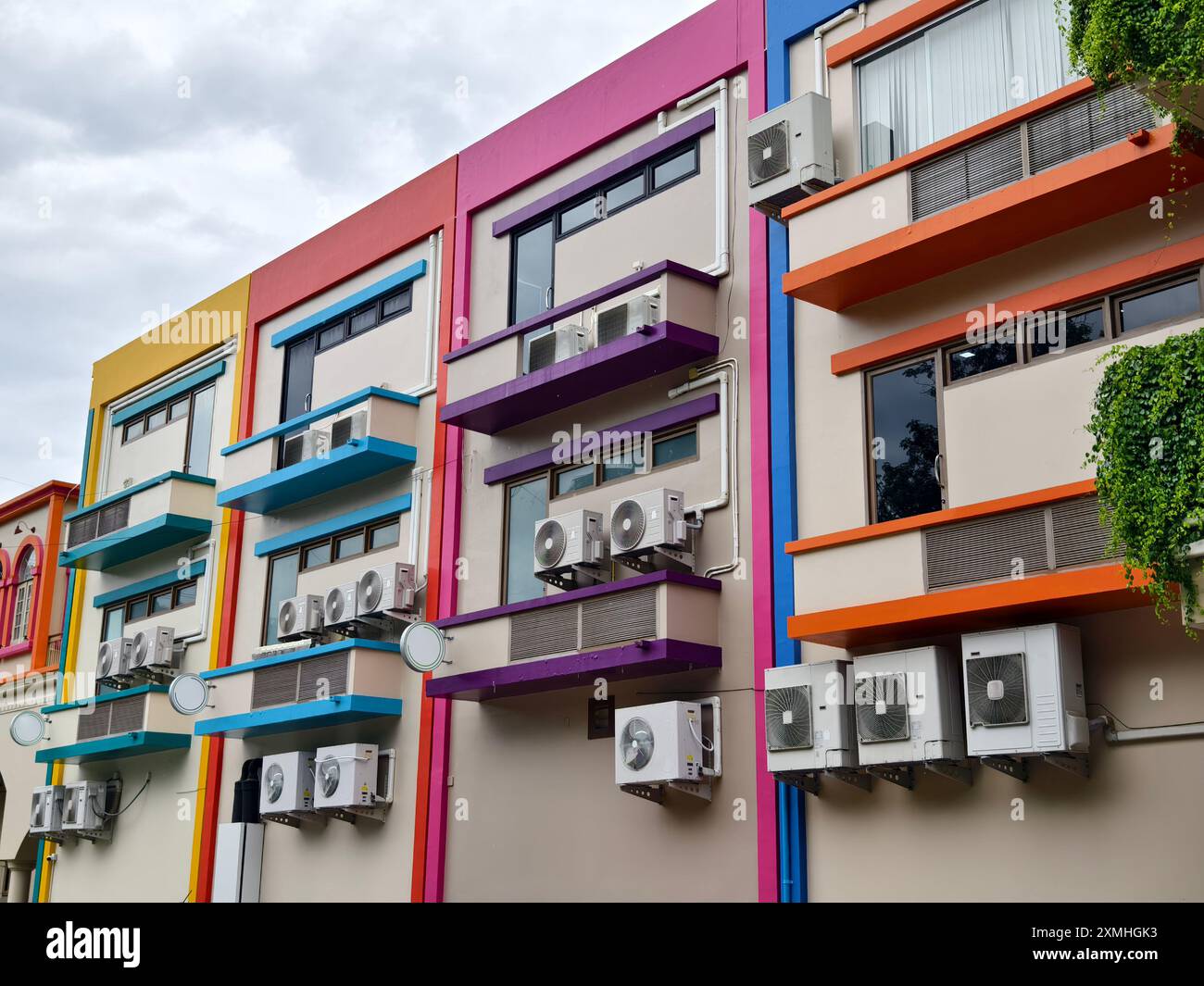 There are numerous air conditioners installed on the exterior of the ...