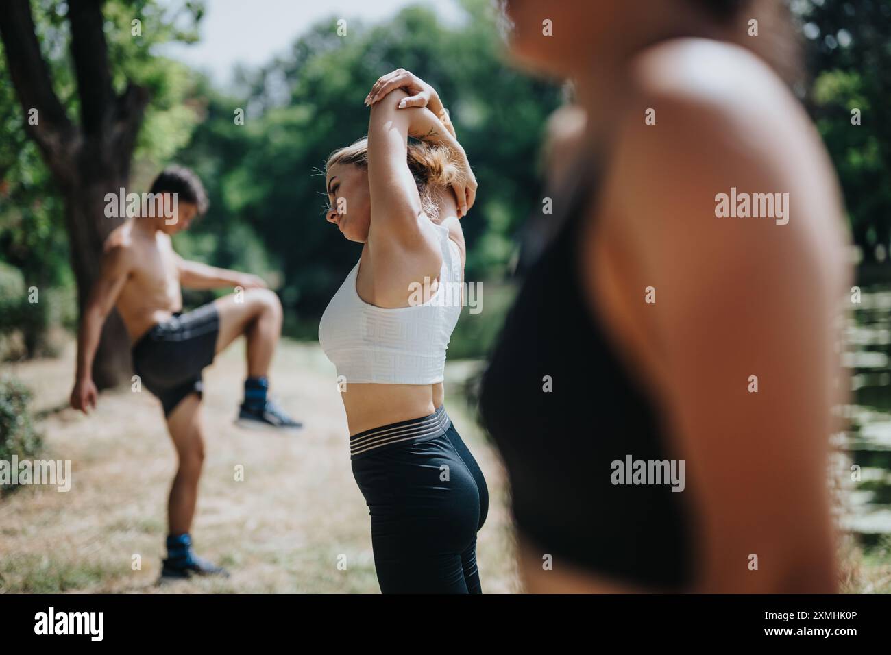 Outdoor workout with a group of friends exercising together in a park ...