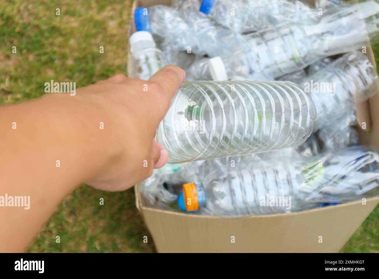 Hand hold and put plastic bottles in to brown recycle garbage box Stock ...