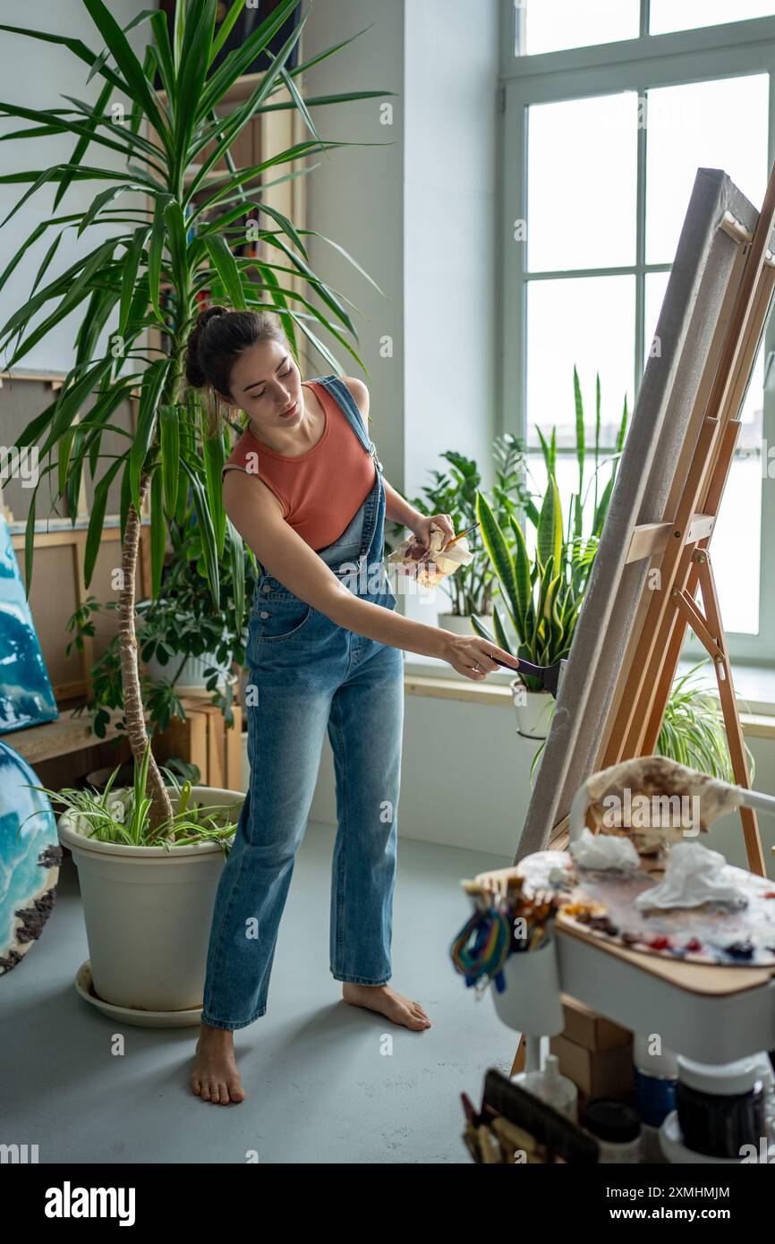 Positive optimistic woman painter embodies creative ideas expresses ...