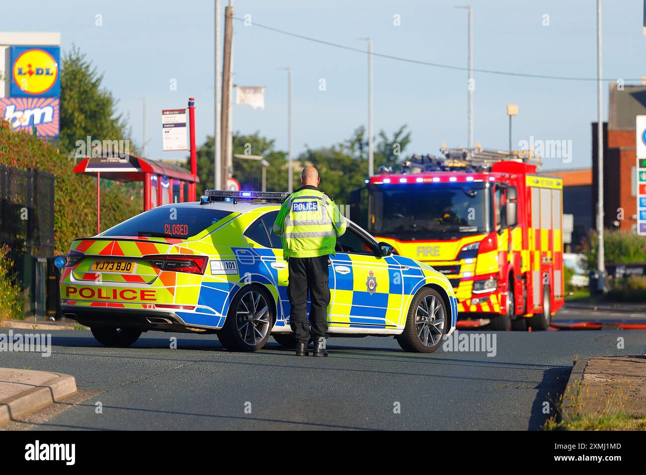 A Police officer stood by his vehicle that is used as a roadblock at an ...