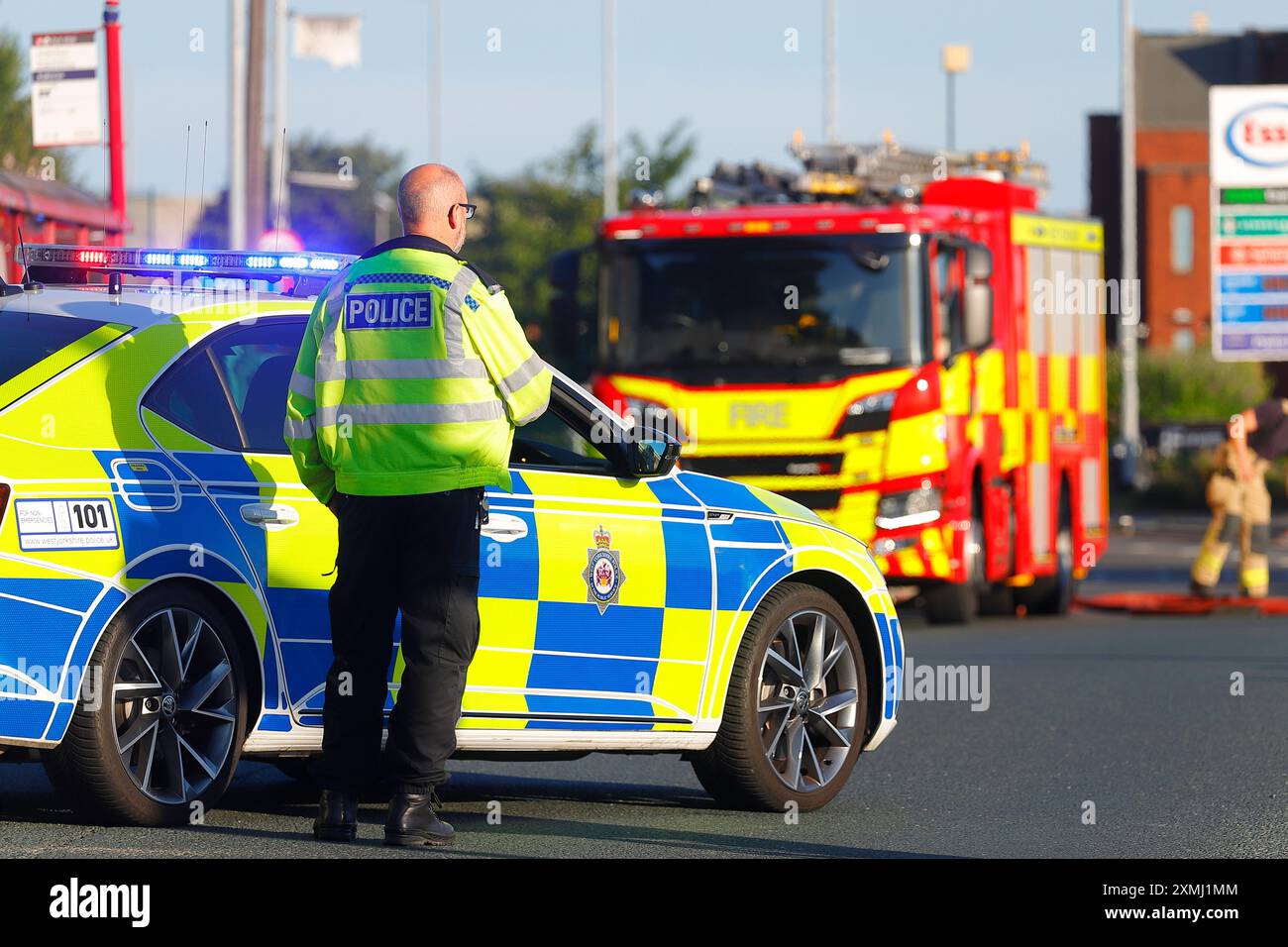 A Police officer stood by his vehicle that is used as a roadblock at an ...