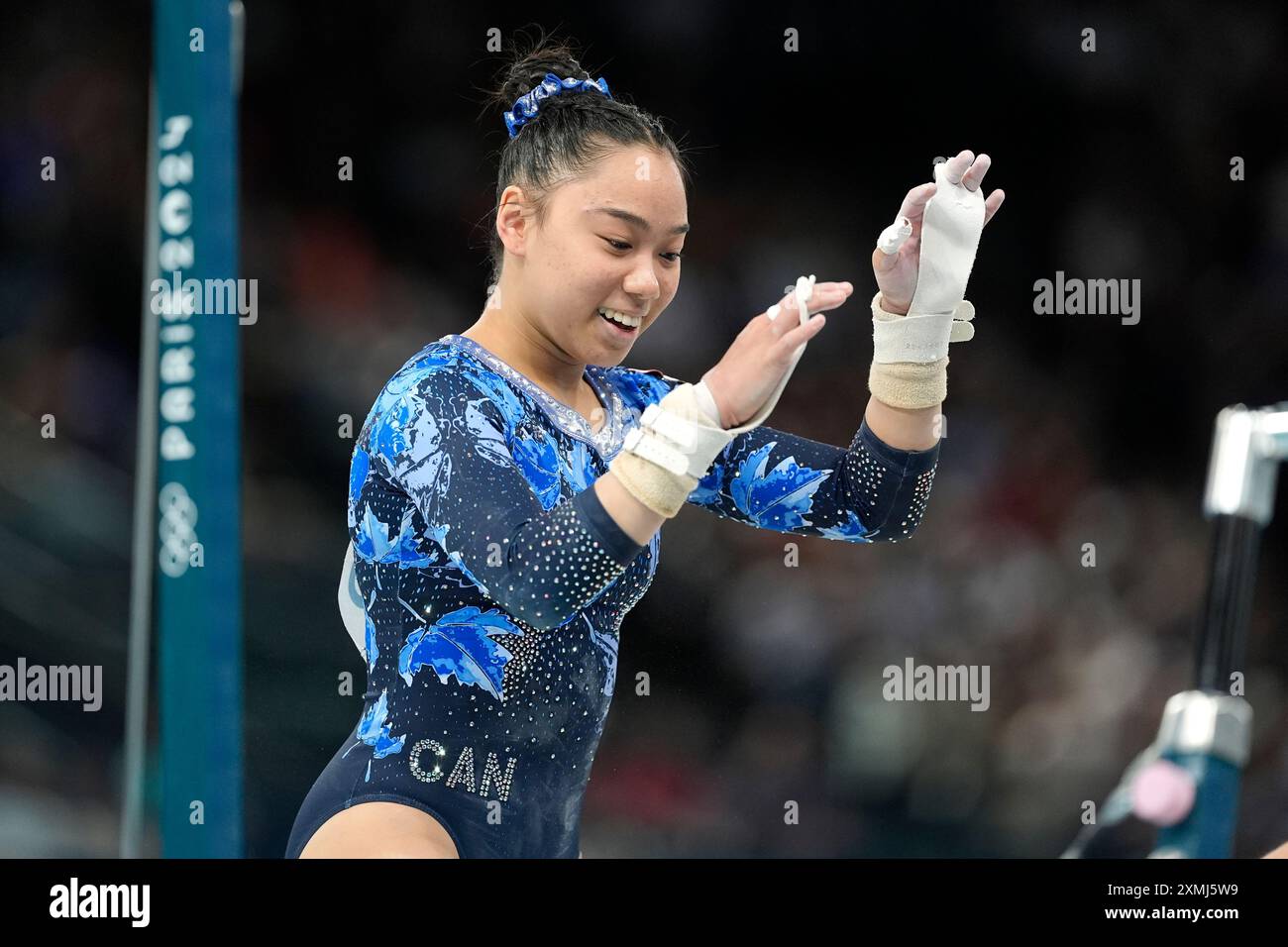 Aurelie Tran, of Canada, reacts after competing on the uneven bars ...