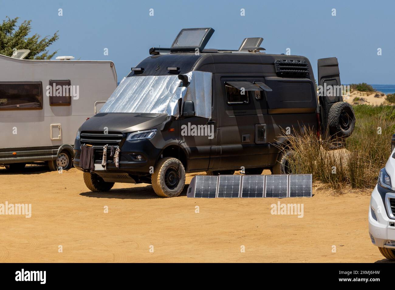 Black Camper Van with Solar Panels in Desert Stock Photo - Alamy