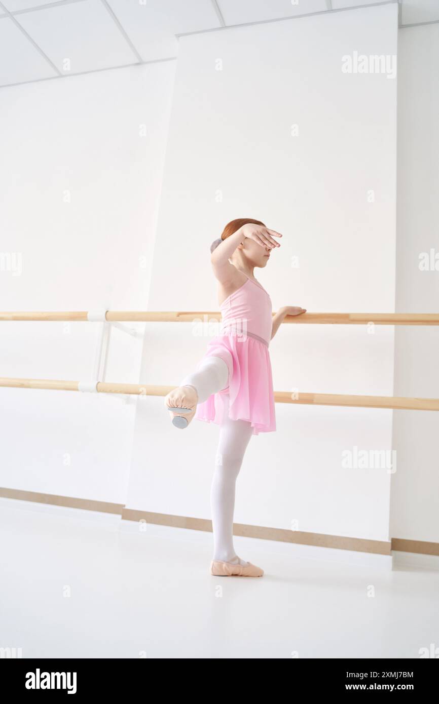 Young ballet girl at studio lesson. Training performance. Stretching ...