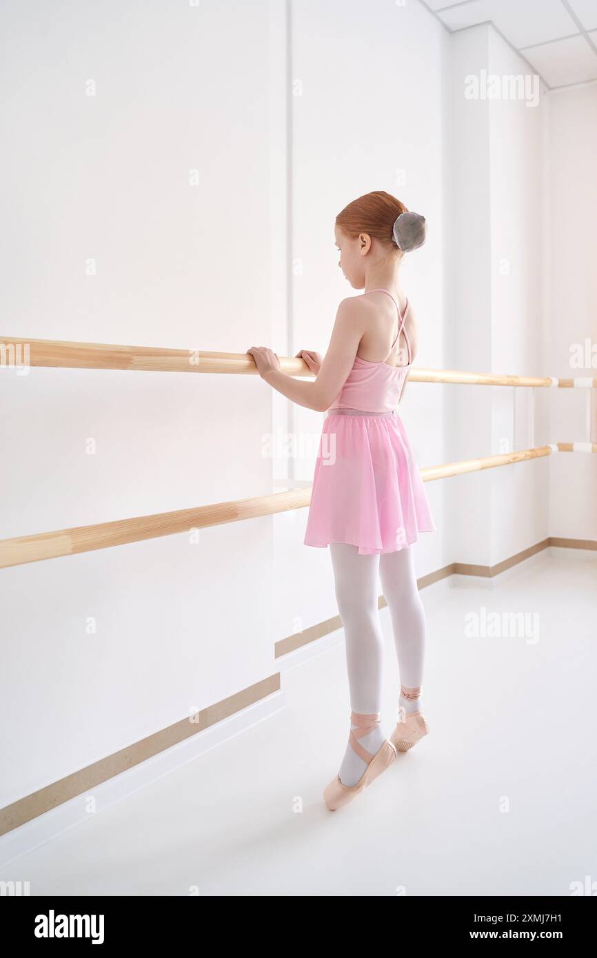 Young ballet girl at studio lesson. Training performance. Stretching ...