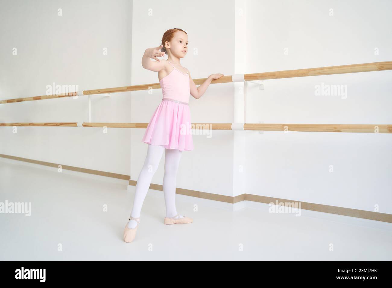 Young ballet girl at studio lesson. Training performance. Stretching ...