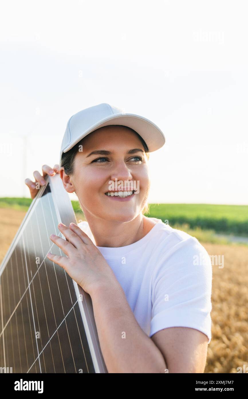 Woman wearing white cap and t-shirt holds solar panel Stock Photo - Alamy