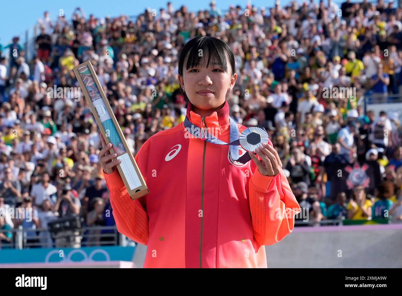 Liz Akama, of Japan, poses on the podium after winning the silver medal ...