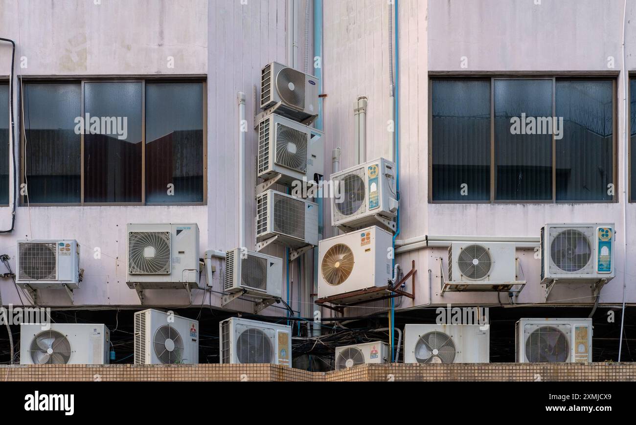 Many AC window units haphazardly stacked on the facade of a building in ...