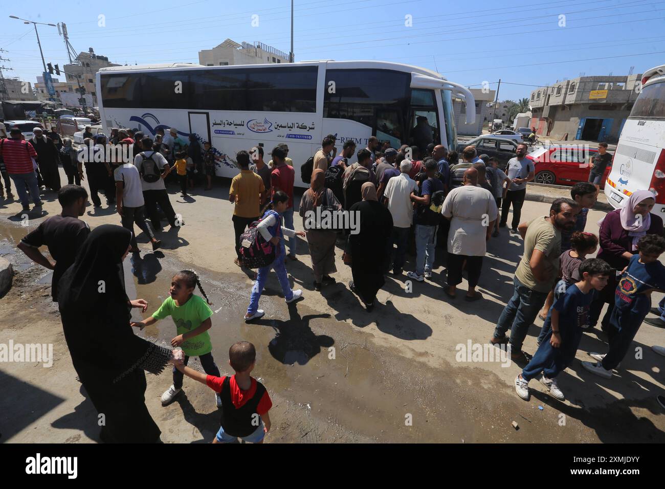 Palestinian patients carry their bags and wait to board buses in the ...