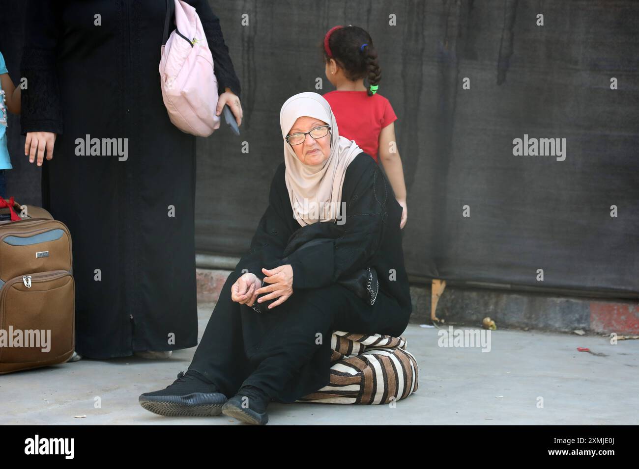 Palestinian patients carry their bags and wait to board buses in the ...