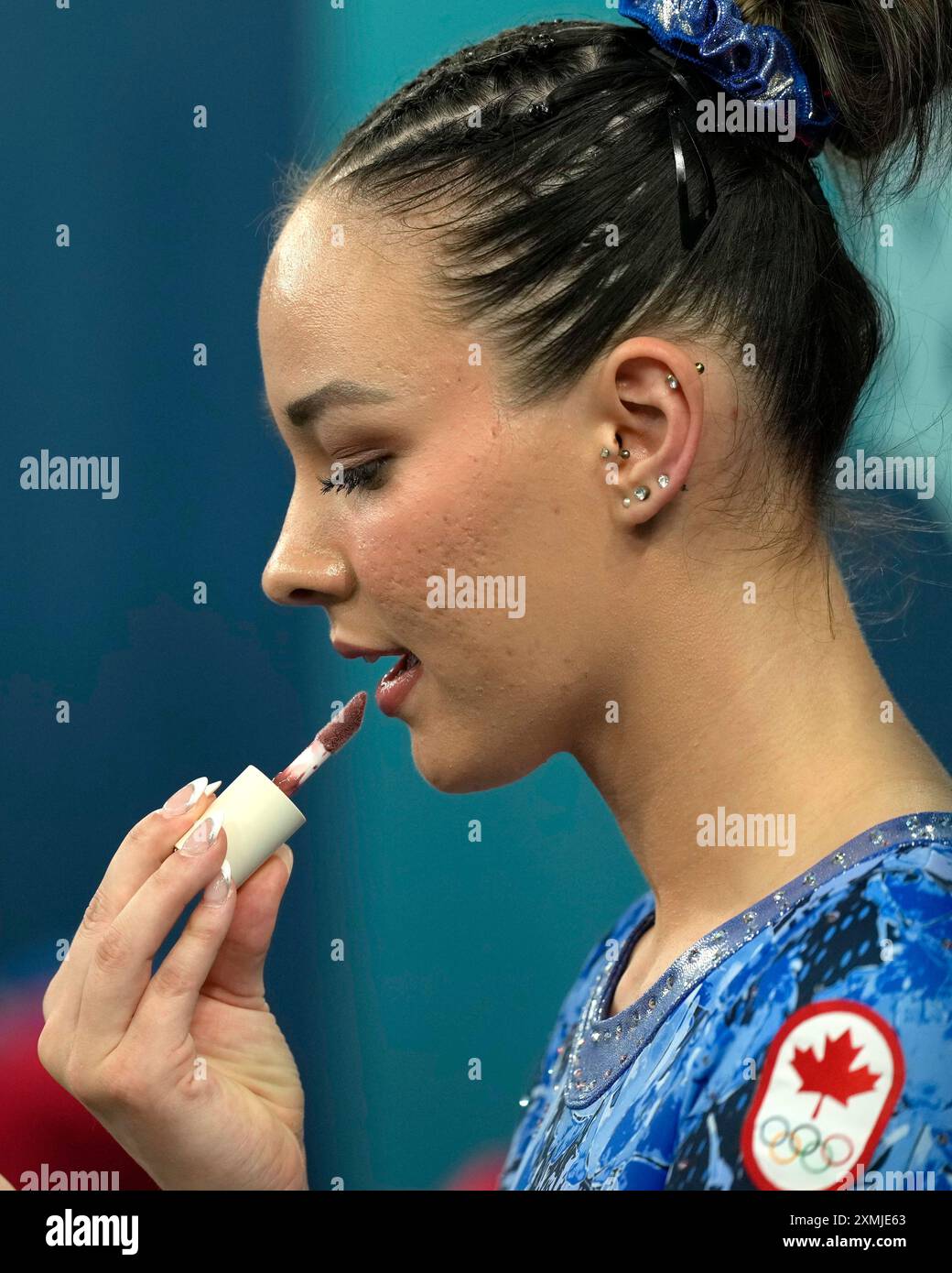 Shallon Olsen, of Canada, touches up her make-up before floor exercise ...
