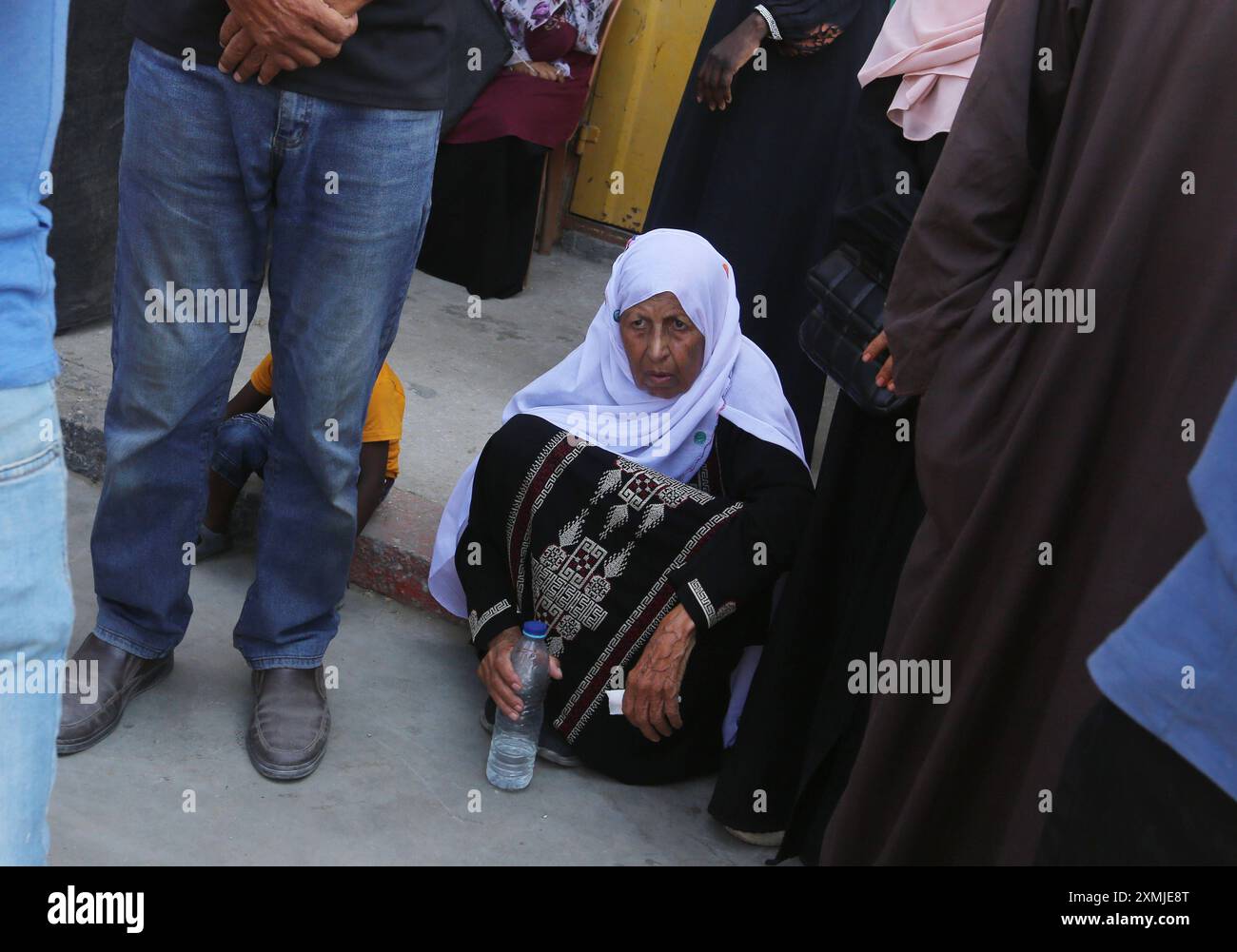 Palestinian patients carry their bags and wait to board buses in the ...