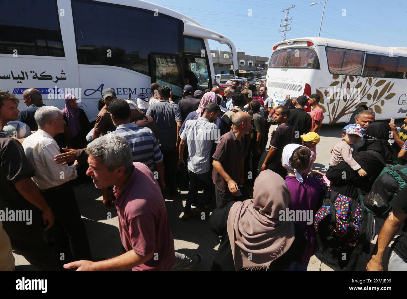 Palestinian patients carry their bags and wait to board buses in the ...
