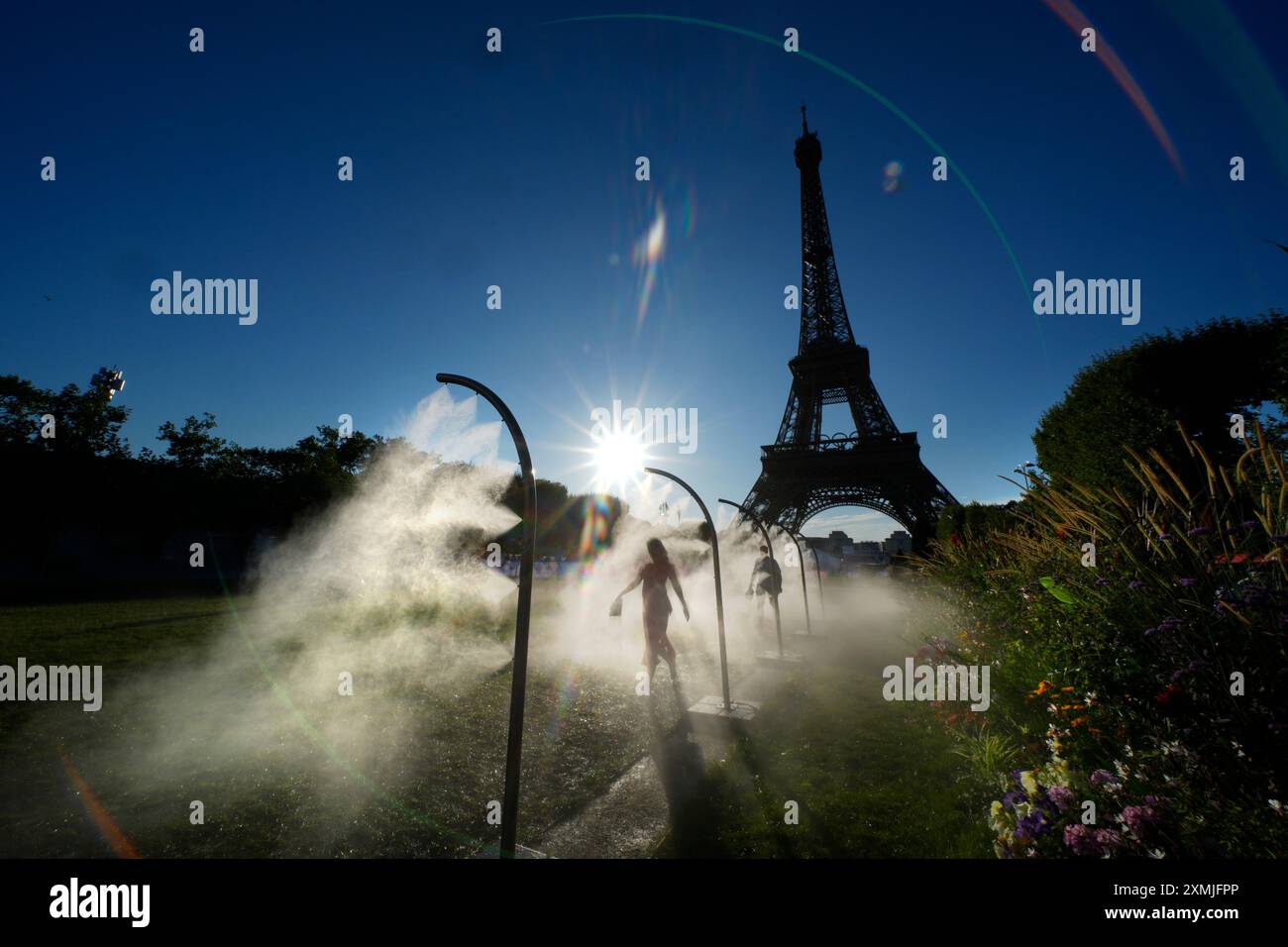 A spectator walks through a water mist sprayers on her way to Eiffel ...
