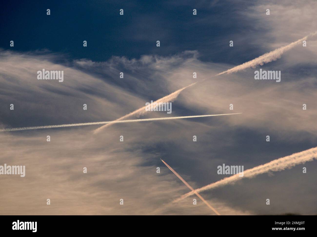 Commercial jet aircraft leave contrails in their wake as they fly high ...
