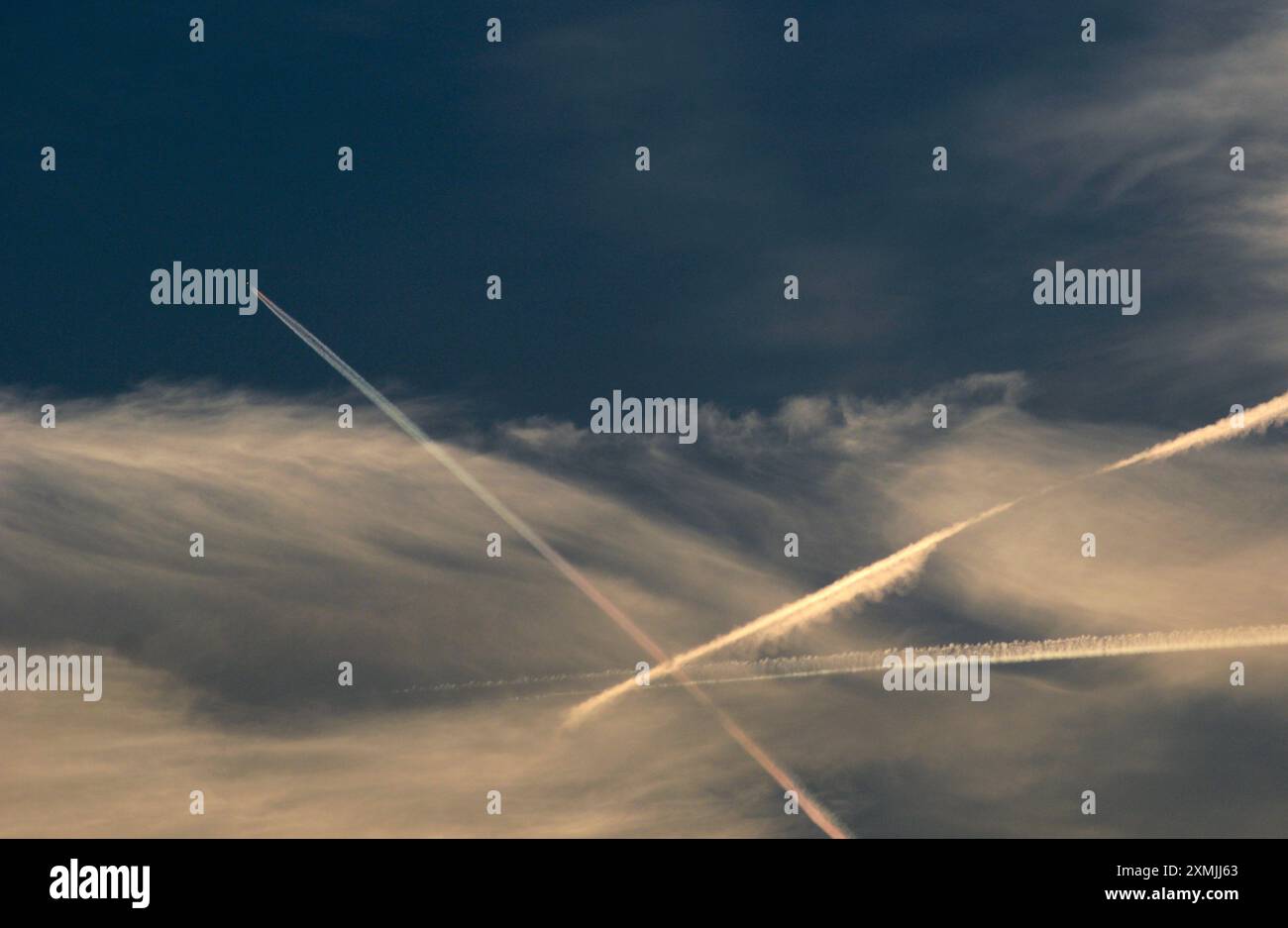 Commercial jet aircraft leave contrails in their wake as they fly high ...