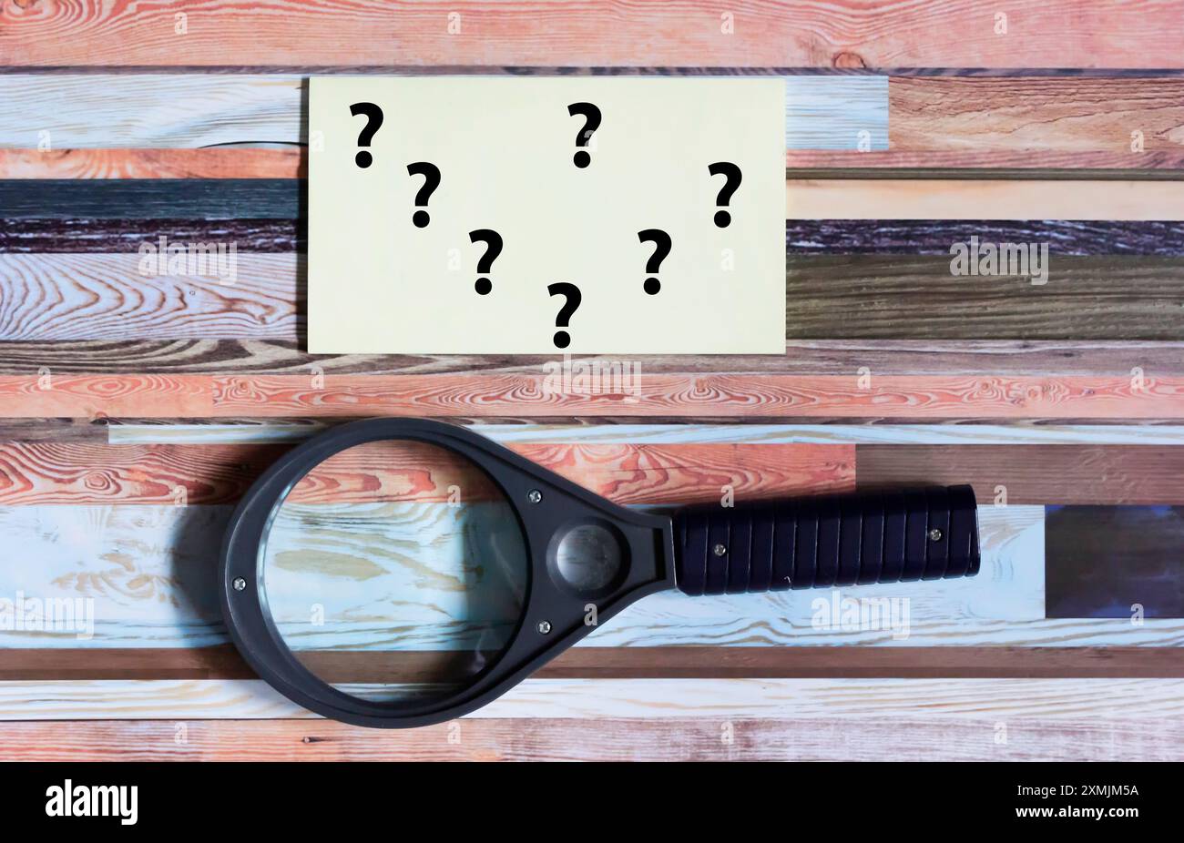 Magnifying glass and question marks on a beautiful background. Search ...
