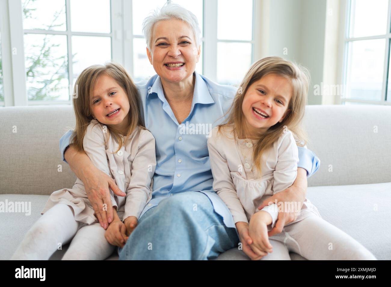 Happy family at home. Two little girls sisters twins grandmother ...