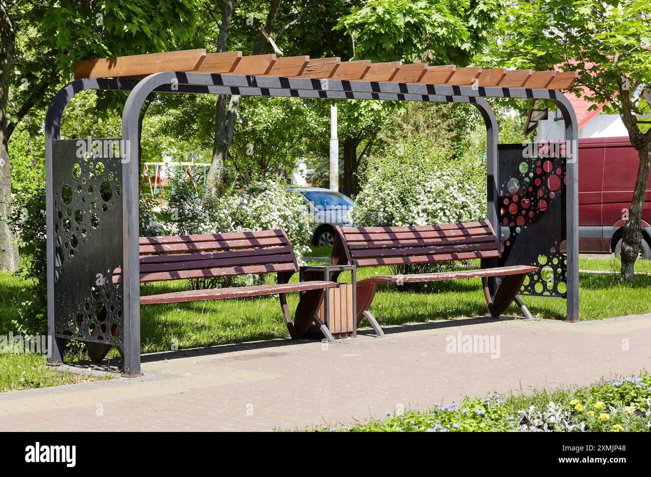 Rest area with bench surrounded by blooming trees and ornamental shrubs ...
