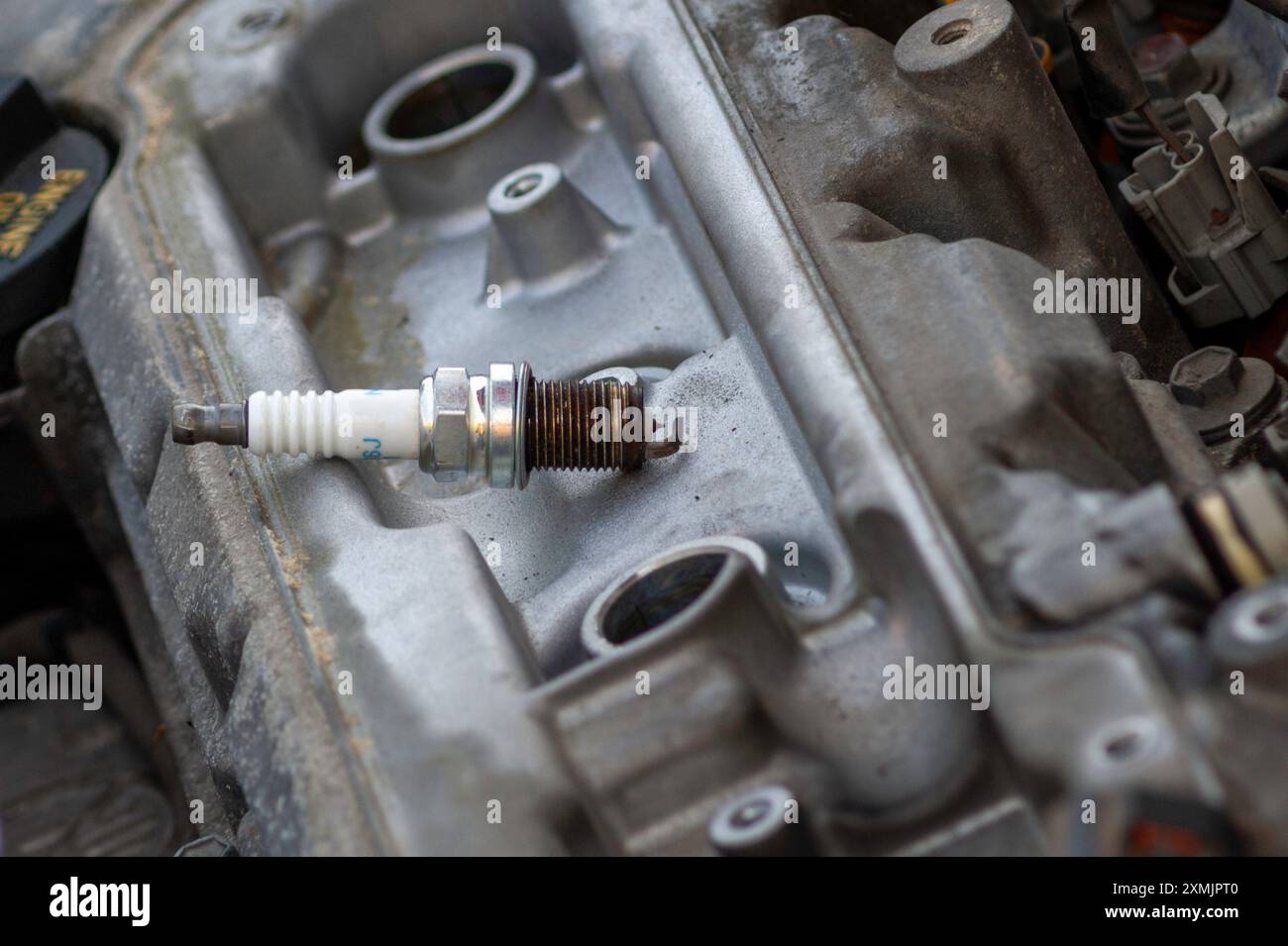 A spark plug on top of the valve cover Stock Photo - Alamy
