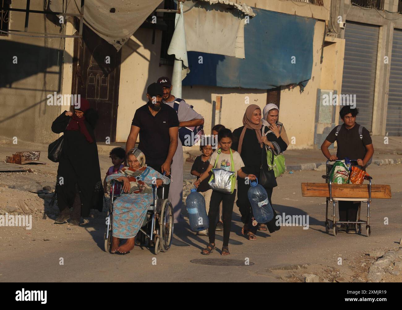 Palestinians carrying their personal belongings flee the al-Bureij ...