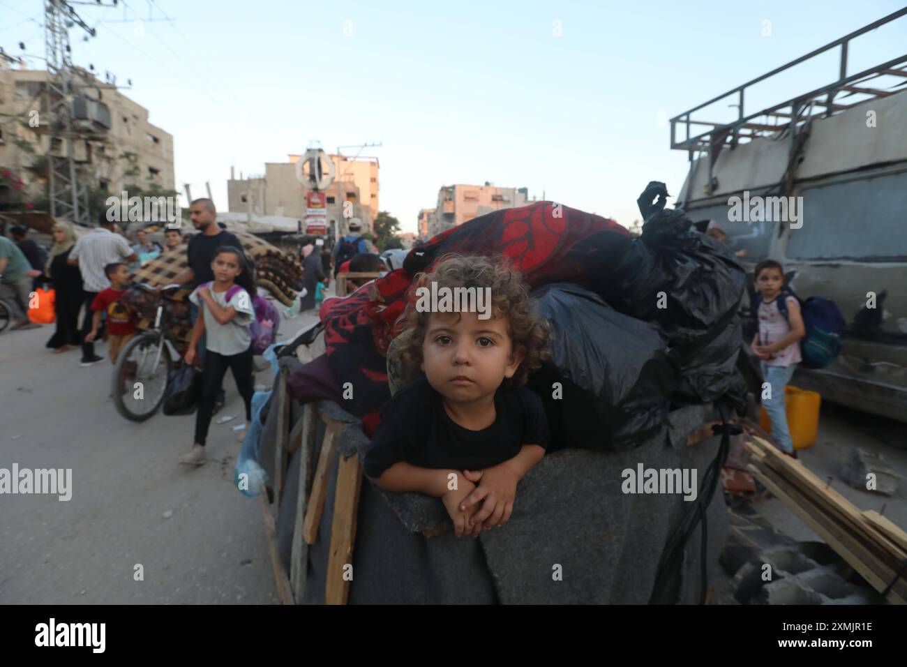 Palestinians carrying their personal belongings flee the al-Bureij ...