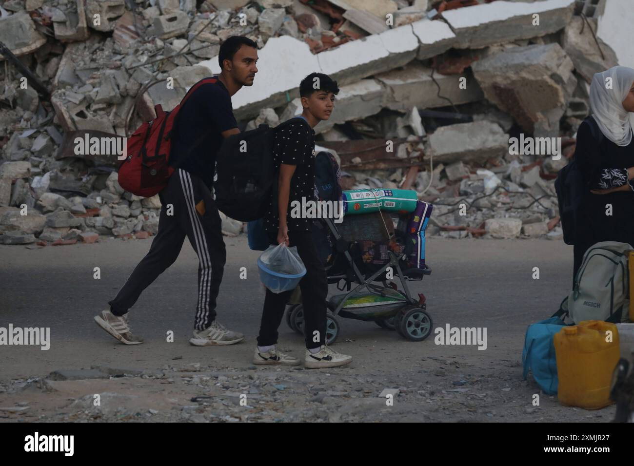Palestinians carrying their personal belongings flee the al-Bureij ...