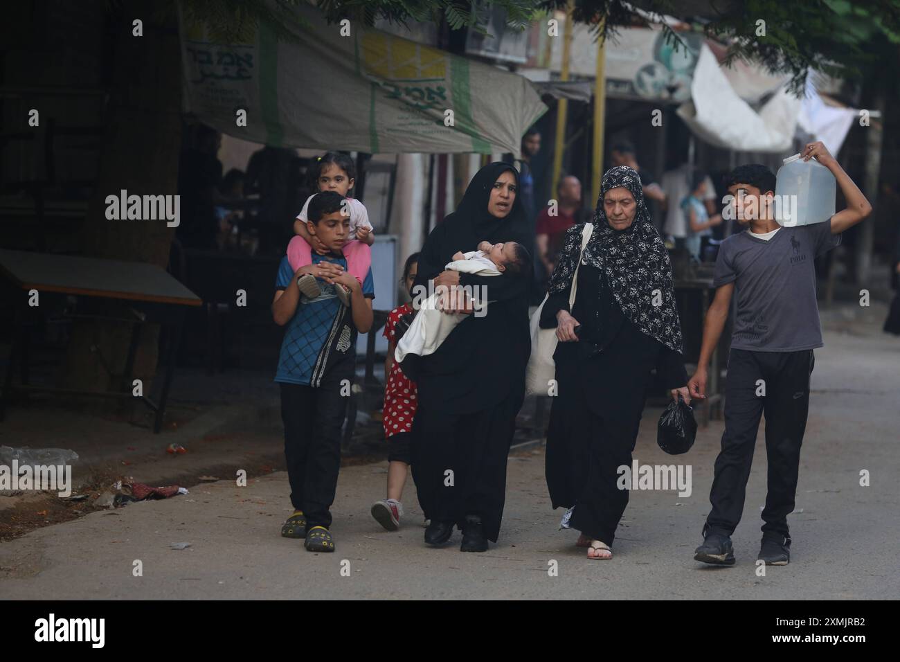 Palestinians carrying their personal belongings flee the al-Bureij ...