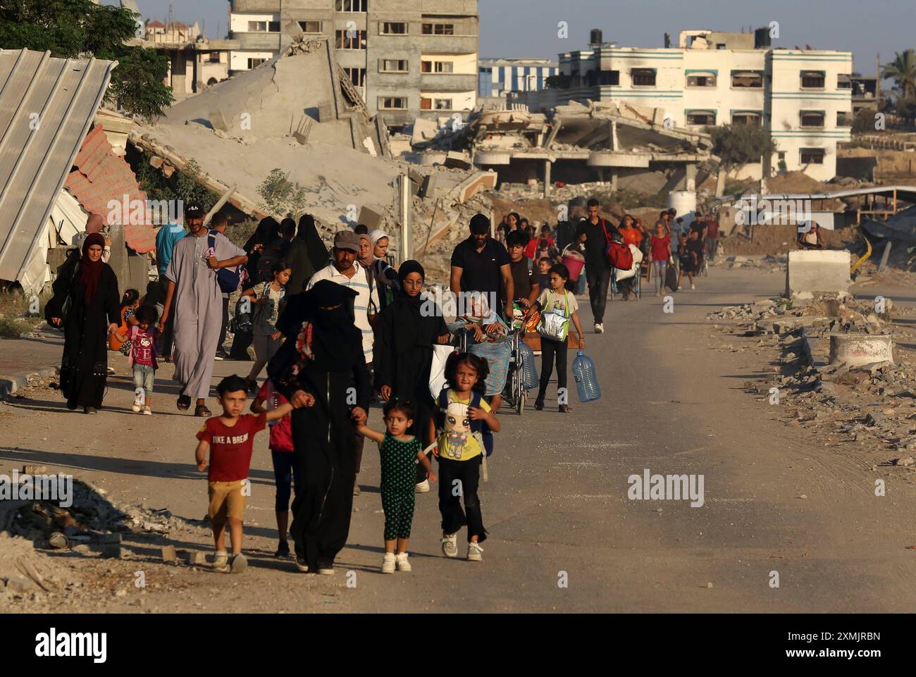 Palestinians carrying their personal belongings flee the al-Bureij ...