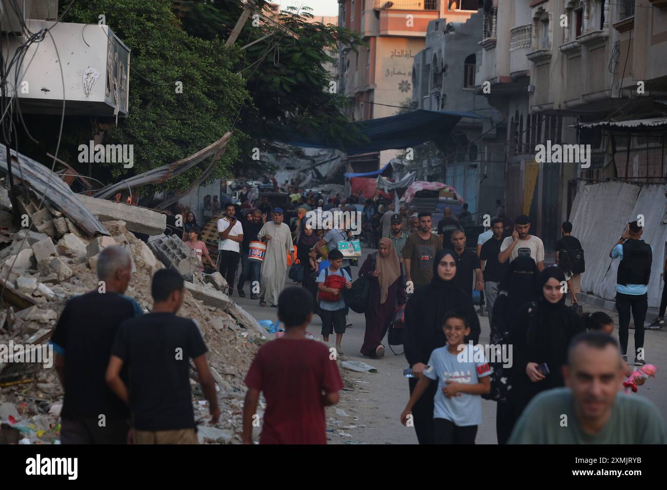Palestinians carrying their personal belongings flee the al-Bureij ...