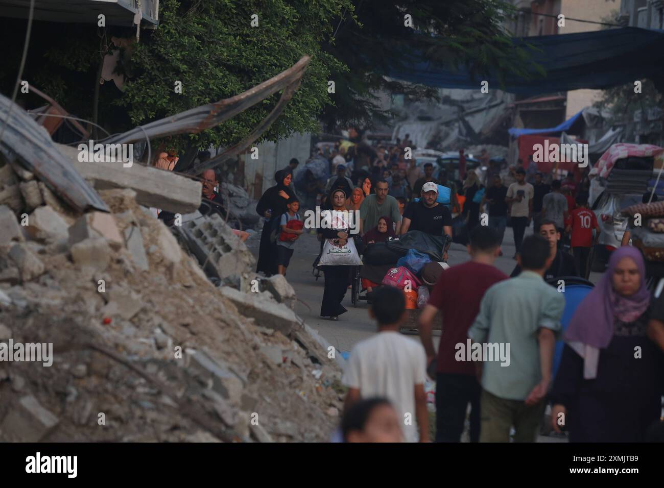 Palestinians carrying their personal belongings flee the al-Bureij ...