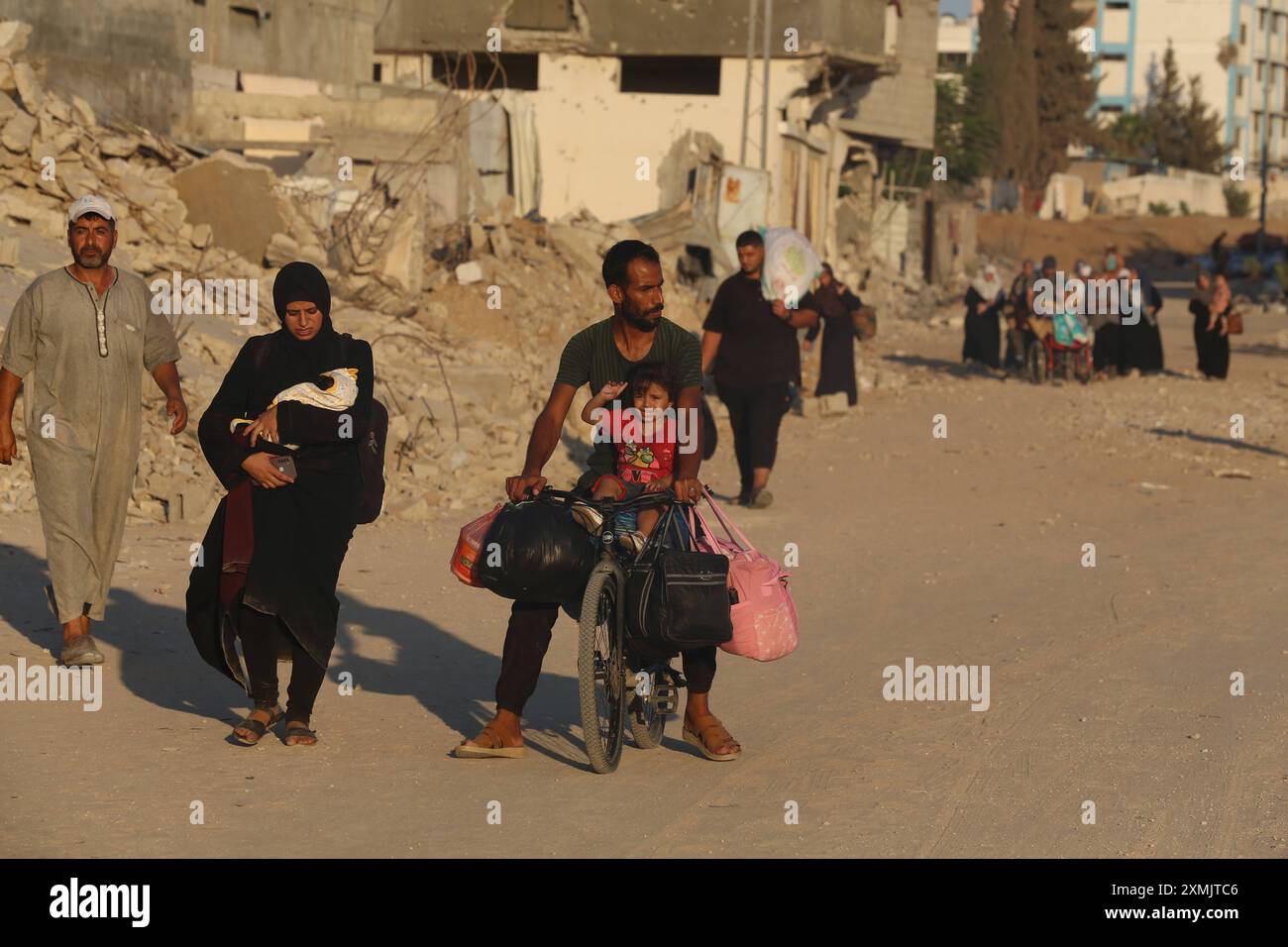 Palestinians carrying their personal belongings flee the al-Bureij ...