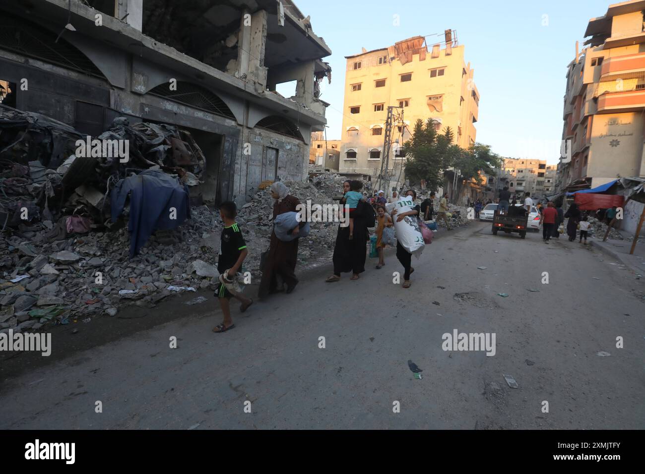 Palestinians carrying their personal belongings flee the al-Bureij ...