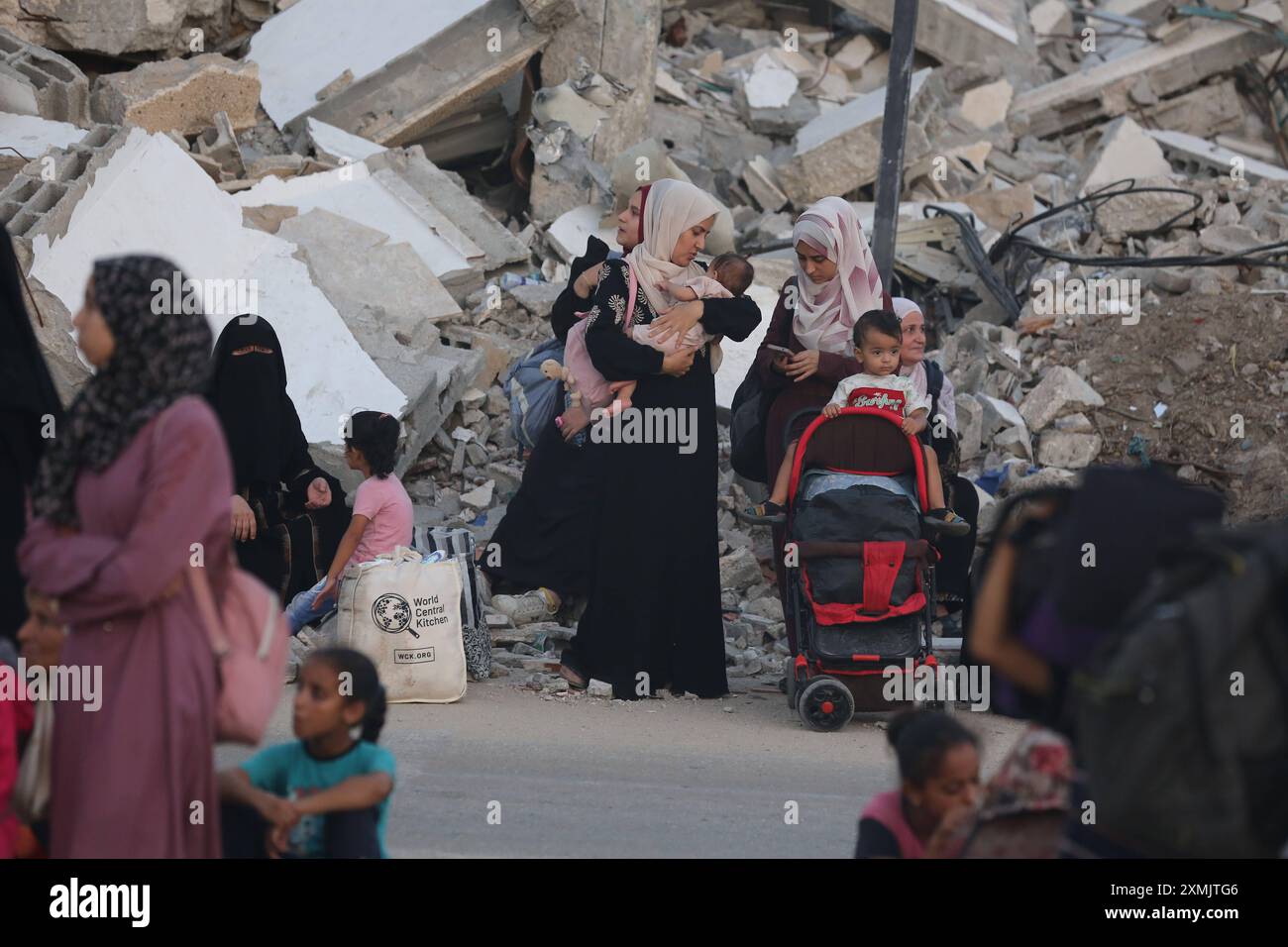 Palestinians carrying their personal belongings flee the al-Bureij ...