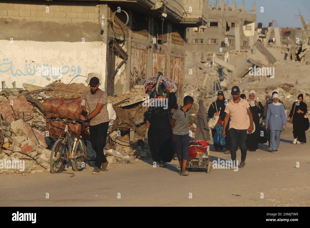 Palestinians carrying their personal belongings flee the al-Bureij ...