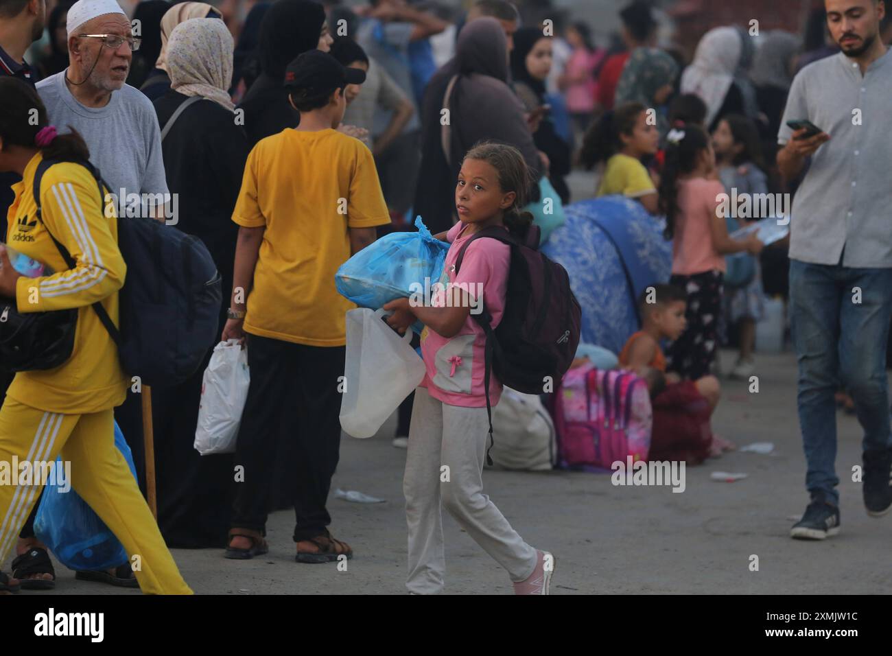 Palestinians carrying their personal belongings flee the al-Bureij ...