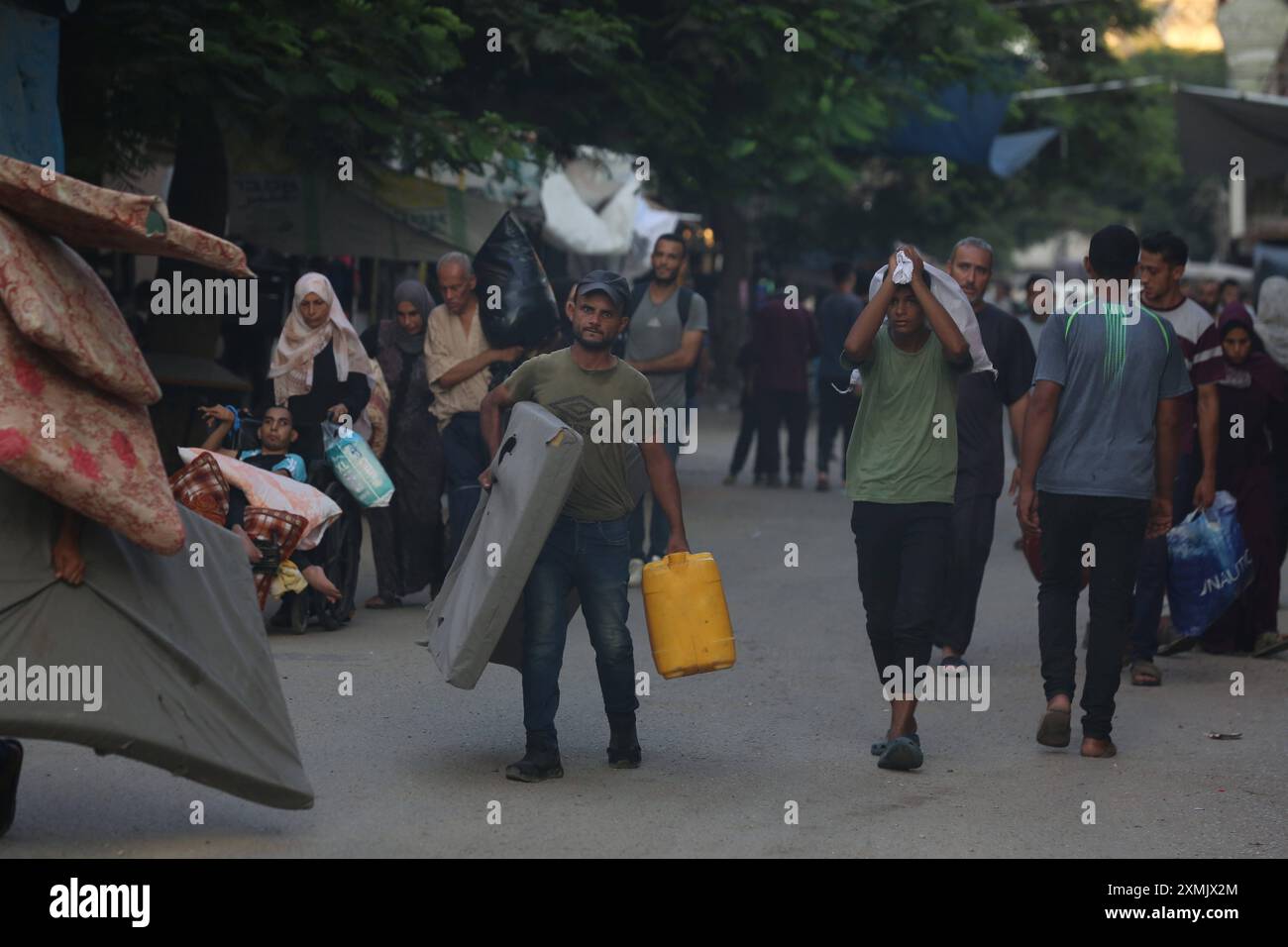 Palestinians carrying their personal belongings flee the al-Bureij ...