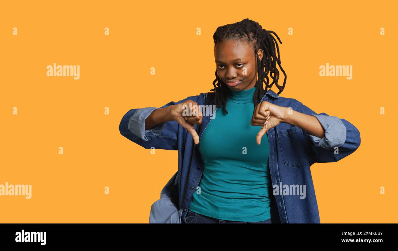 Frustrated woman showing thumbs down sign gesturing, disapproving ...