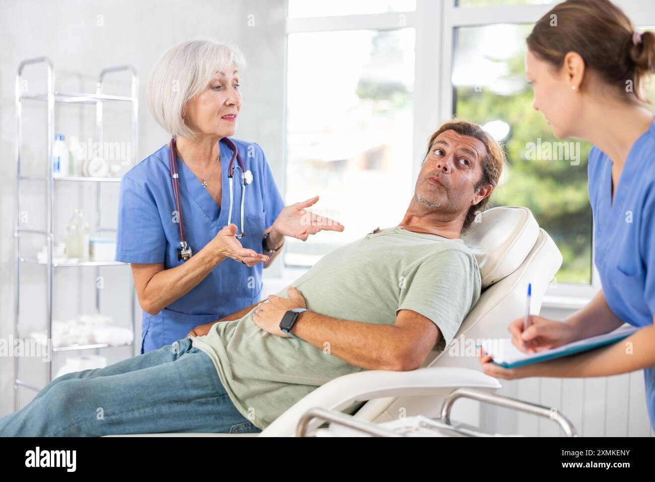 Sick male patient having aching belly and visiting doctor Stock Photo ...
